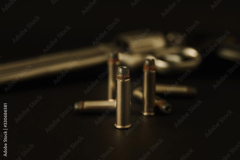357 Caliber hollow point bullets near revolver pistol gun on black ...