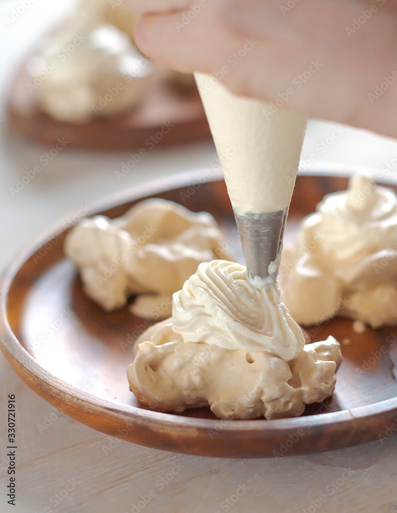 the process of creating Pavlova dessert, decorating the meringue with ...