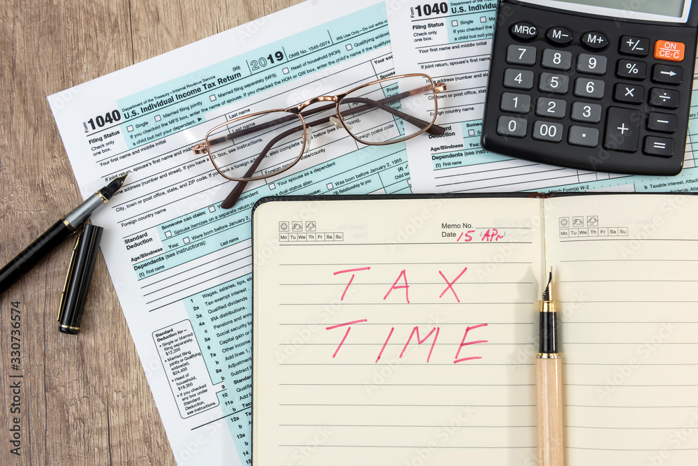 Tax form 1040 with notepad and text tax time, pen and calculator. Tax ...