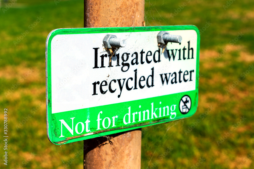 Selective focus. Irrigated with recycled water, do not drink warning ...