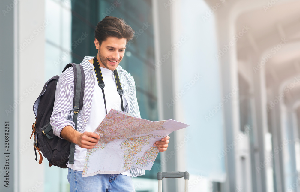 Happy Tourist. Young Man Standing Near Airport With Map In Hands Stock ...