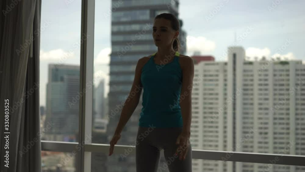 Woman exercising, doing warmup by window by window at home Stock Video ...