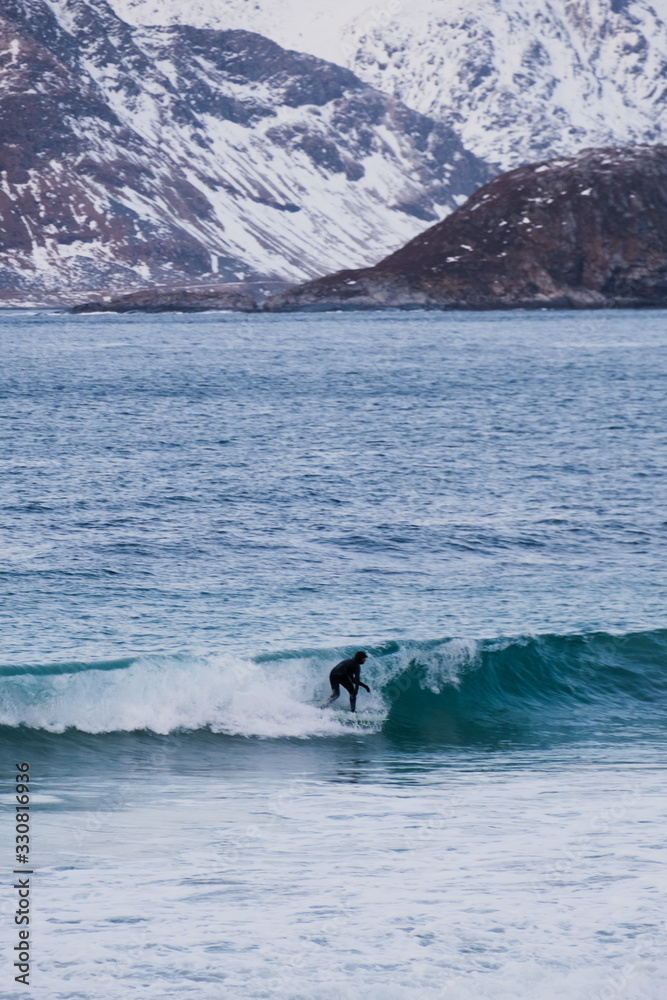 Surfing in cold ocean in Lofoten islands. Famous destination for ...