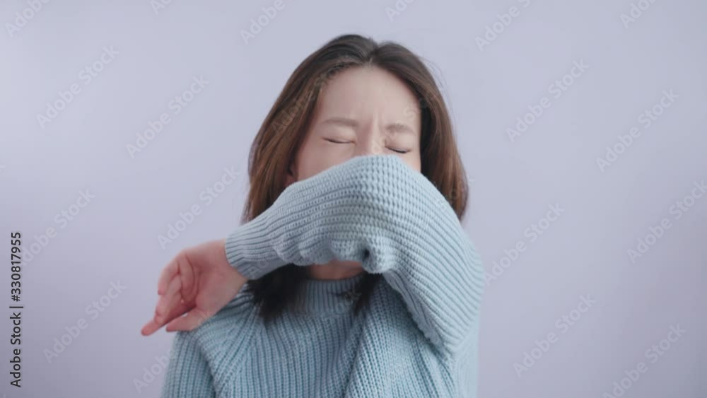 young woman sneezing,coughing into his arm or elbow to prevent spread ...