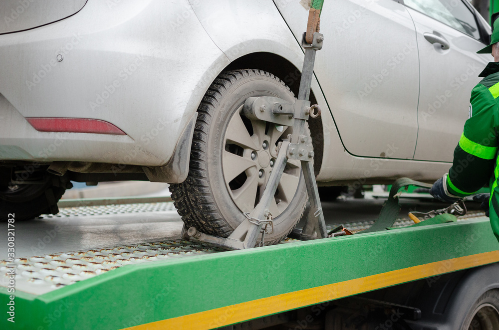 Tow truck lifting the car for improper parking. The utility service ...