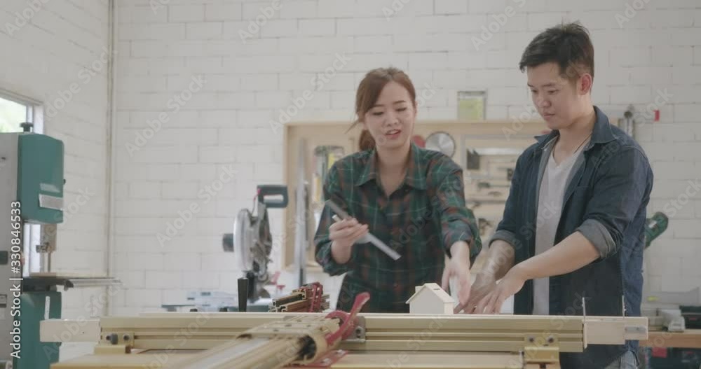 Two carpenter teamwork building design wood house model measure scale ...