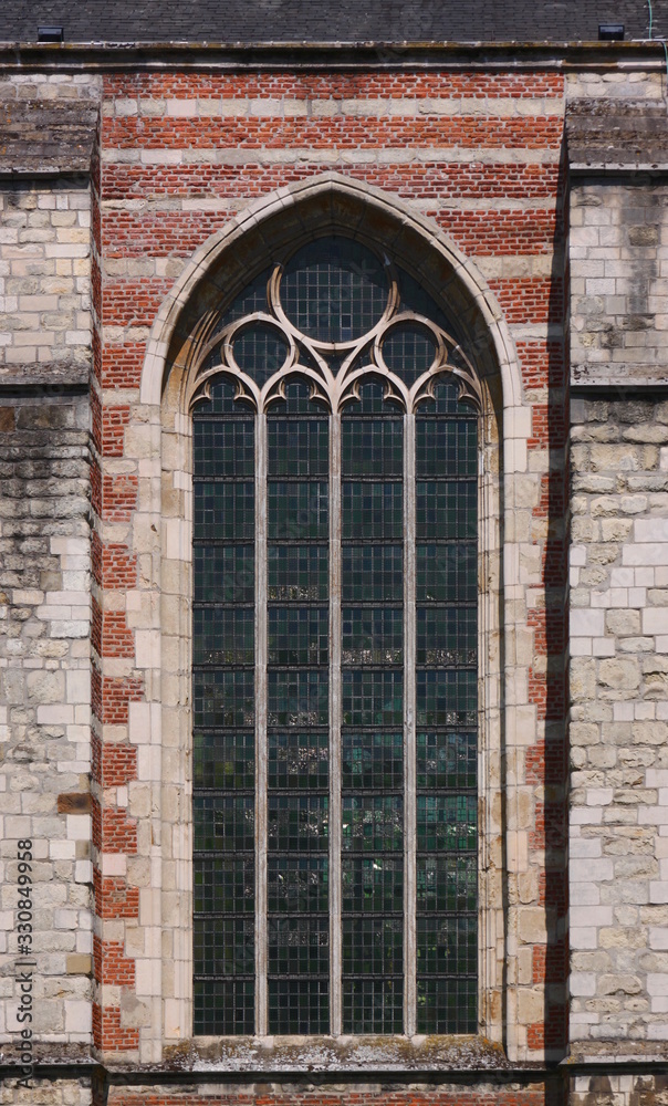 Pointed ogive arch with gothic window at the brick facade of Goes city ...