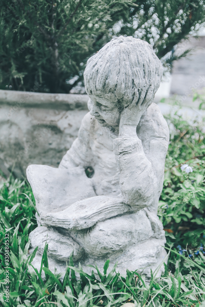 Backyard Statue Decorations on a sunny day the boy statue is sitting ...