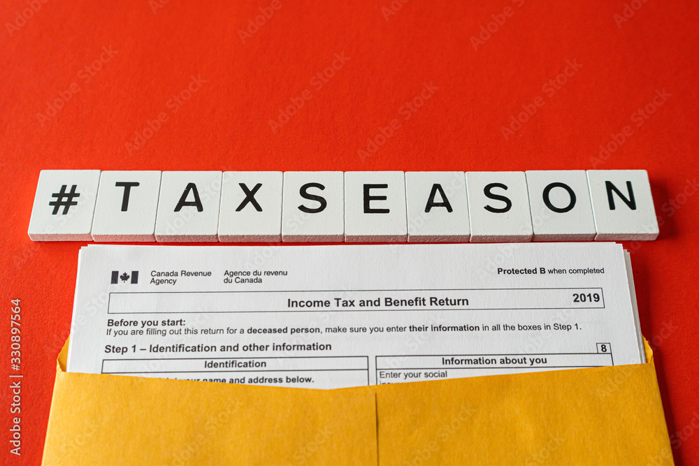 Letter tiles spelling taxseason with envelope containg Canada T4 Tax ...