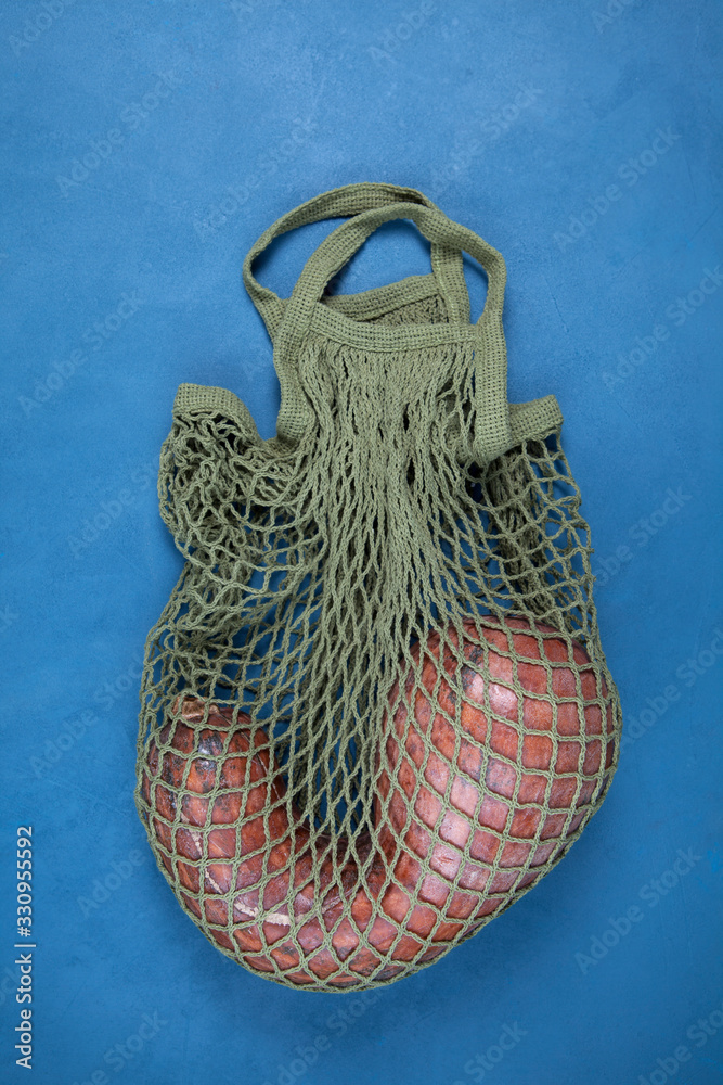 Funny, curved pumpkin butternut of the Guitar variety in a string bag ...