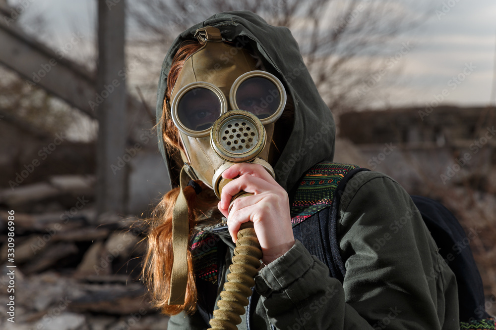 Human in gas mask among ruins and dramatic sky background. Enviromental ...