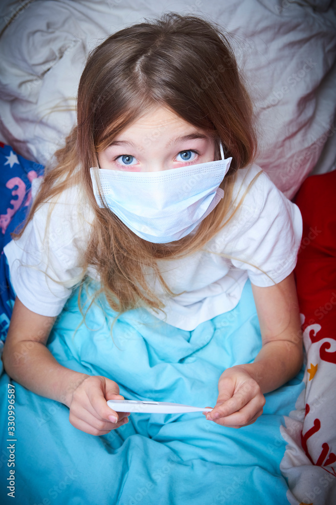 Sick girl lying in bed with protection mask on face against infection ...