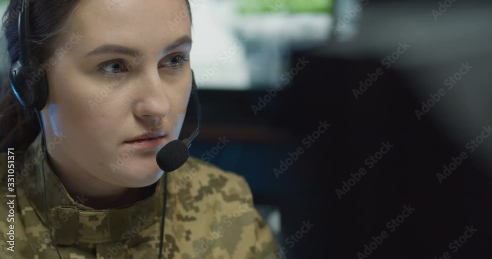 Portrait of Caucasian military woman in headset sitting at computer ...