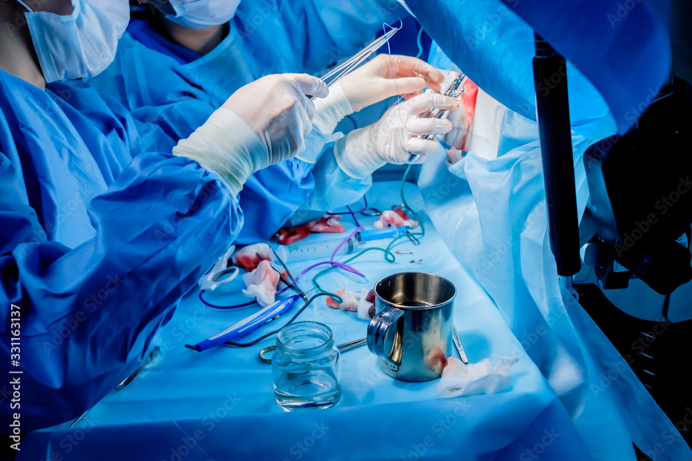 Bloodied hands of surgeons in sterile latex gloves with surgical ...