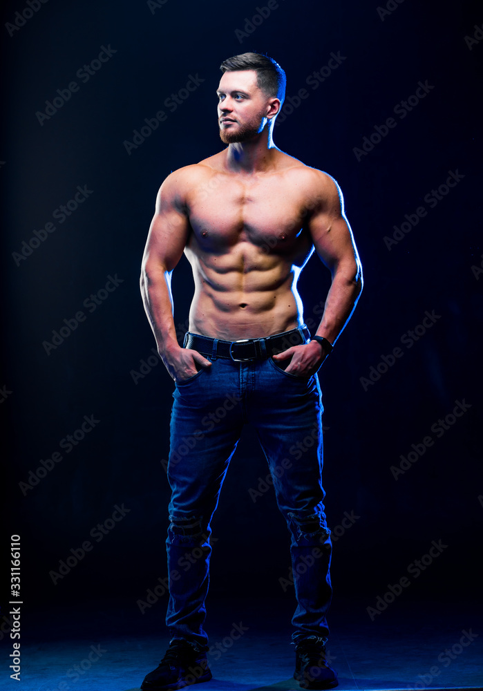 Bodybuilder posing on black background. Muscular and fit young ...
