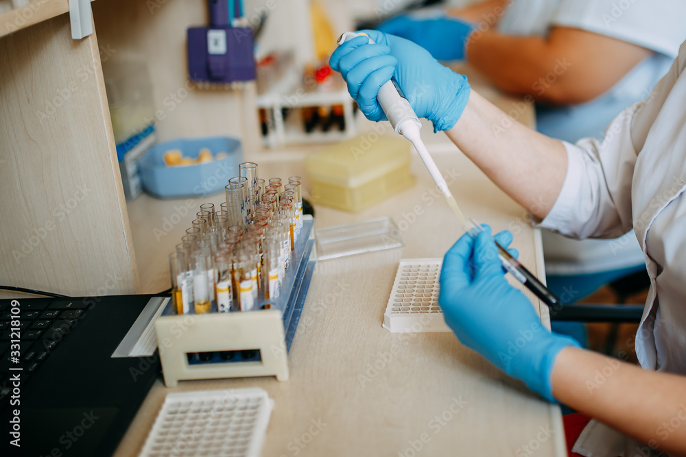 Blood test process in laboratory. Doctor hands making blood test. Many ...