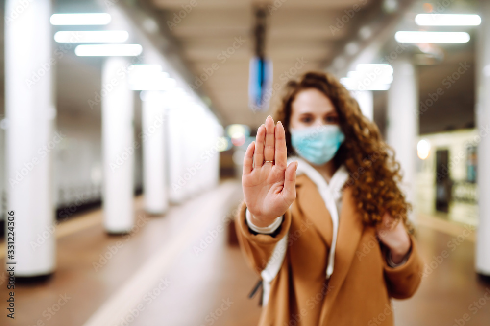 Hand stop sign. Woman in a sterile medical mask on her face, shows stop ...