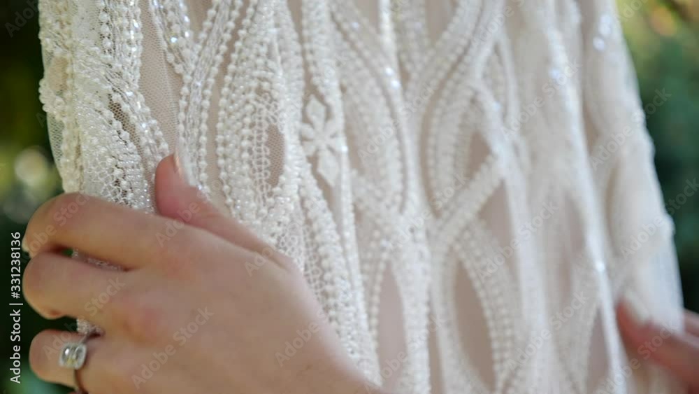 Bride moving her hand on her wedding dress, close up shot in slow ...