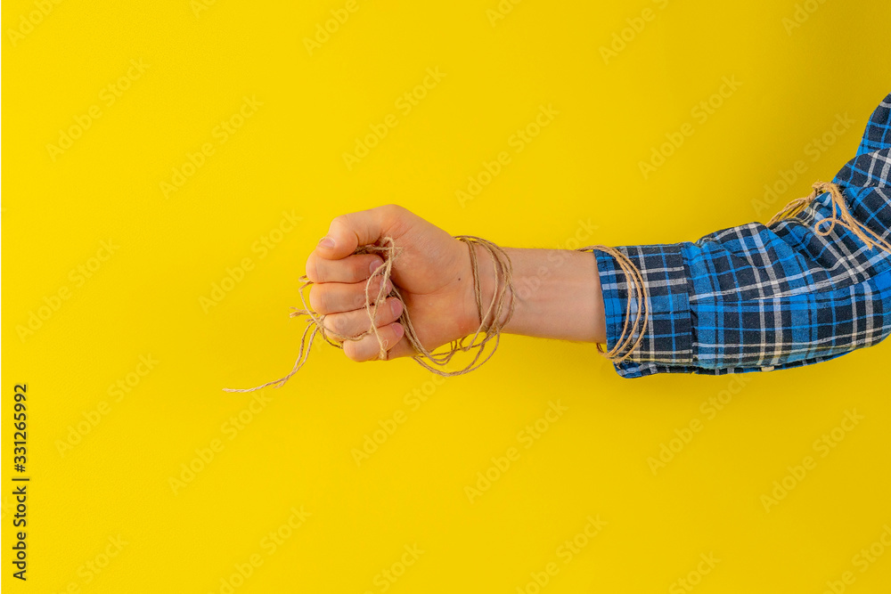 person's hand in the rope tighten against the colorful background ...