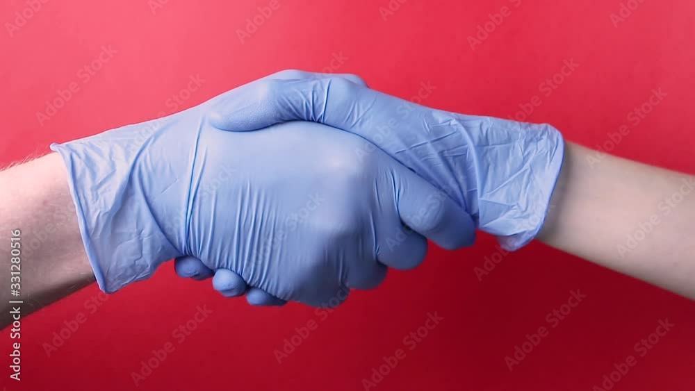 Handshake in rubber medical gloves. The concept of a pandemic ...