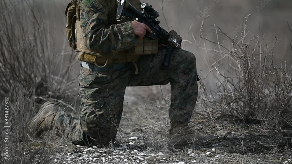 US army soldier holding automatic rifle in defense position during ...