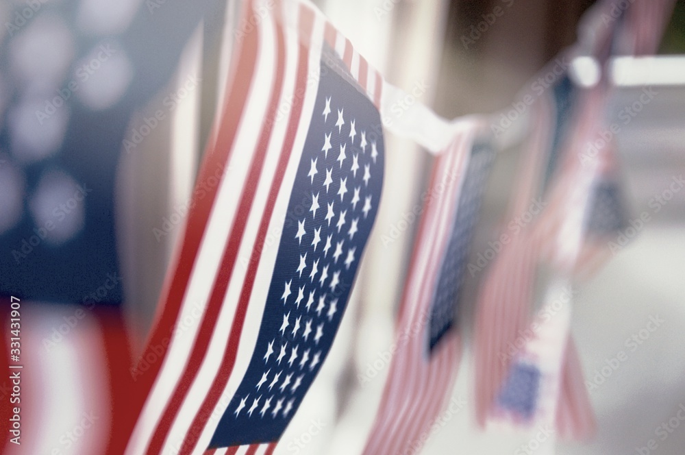 Row of small identical American flags, decorative for themes of summer ...