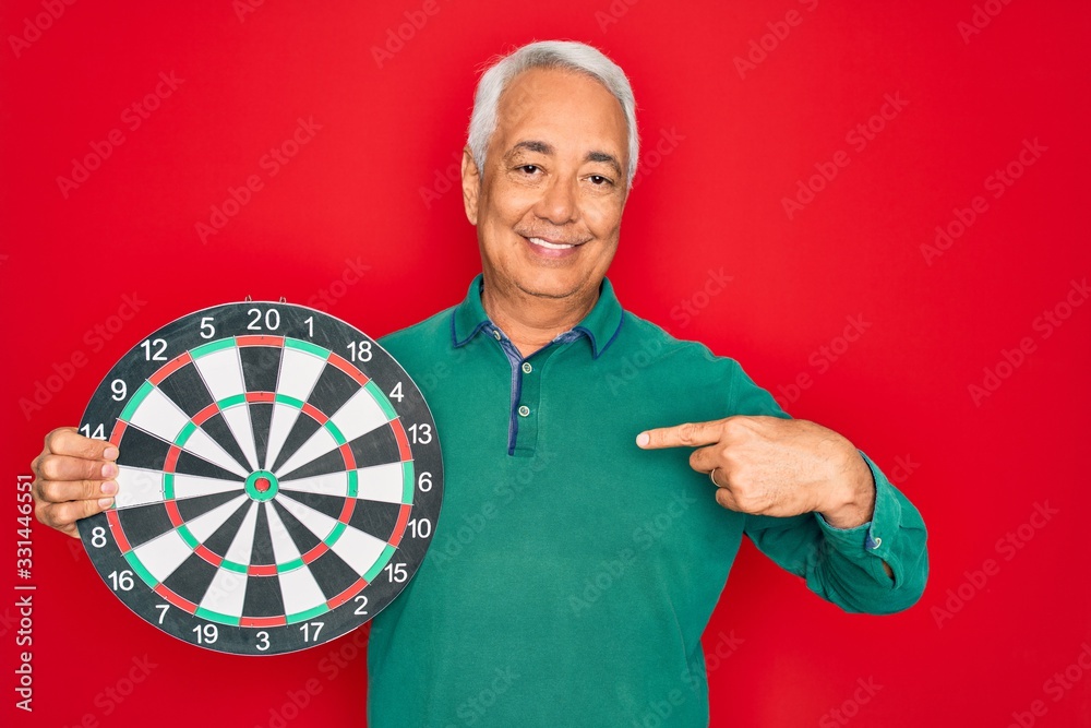 Middle age senior grey-haired man holding competition dartboard target ...