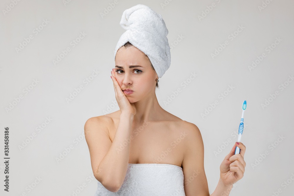 young sad caucasian woman with tooth brush suffering from tooth pain or ...