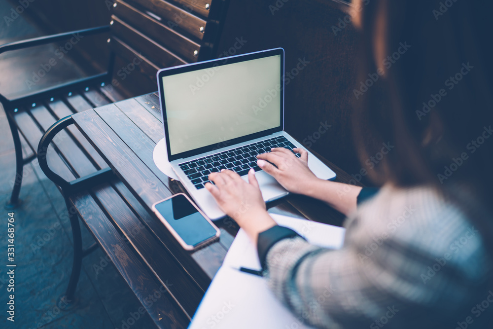 Cropped image of female freelancer typing on laptop computer with mock ...