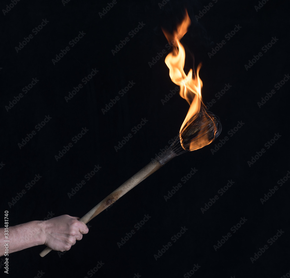 wooden burning torch on a black background Stock Photo | Adobe Stock
