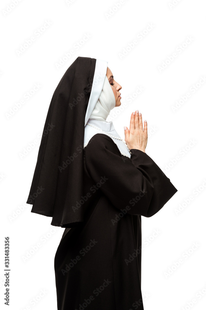 beautiful nun praying with closed eyes and hands together isolated on ...
