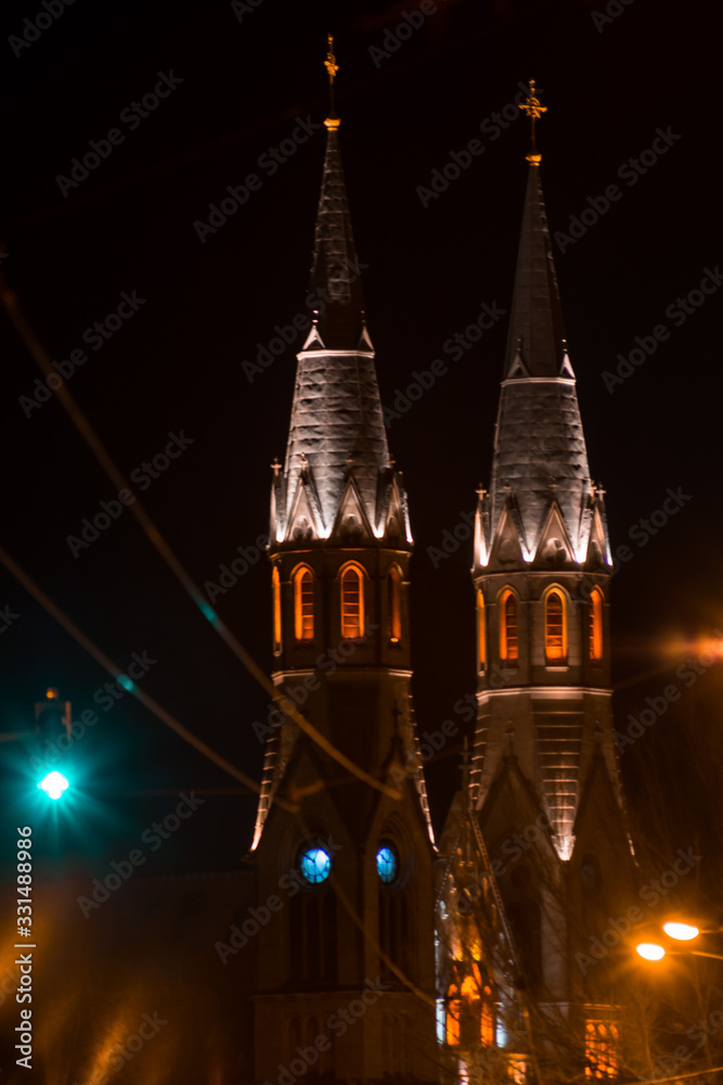 View of church towers. Illuminated towers of a neogothic church. Night ...