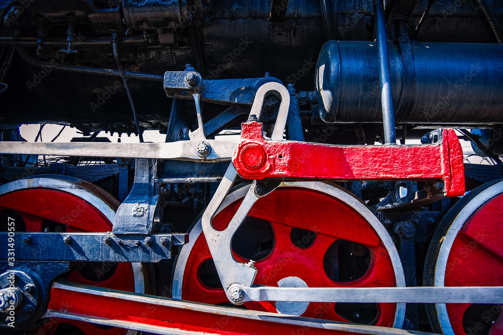 Red driving wheels of a vintage steam engine locomotive. Driving rods ...