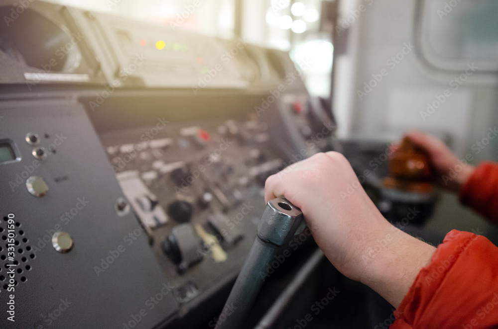subway train cabin and dashboard. Hand of subway driver on the lever of ...