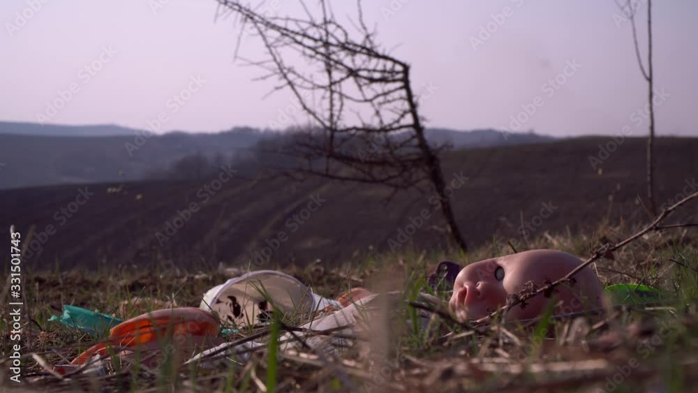 Vidéo Stock Old broken doll lying on the garbage. An eerie doll lying ...