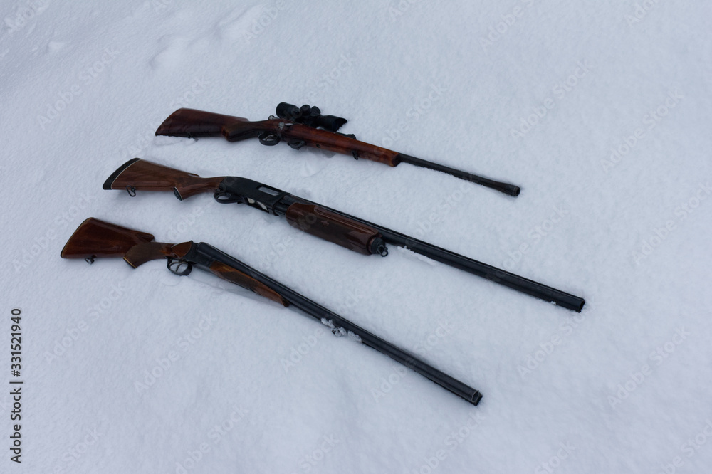 rifle, double barrel shotgun and pump action shotgun in the snow Stock ...
