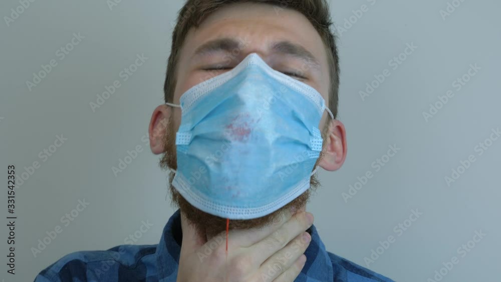 Infected young man wearing medical face mask is coughing up blood ...