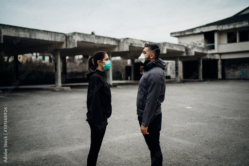 Two people in masks talking from distance.Couple being divided by ...