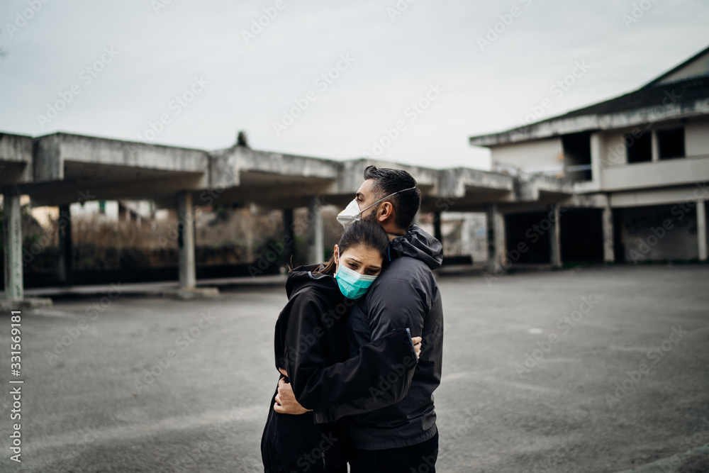 Two people in masks hugging.Couple being divided by incurable ...
