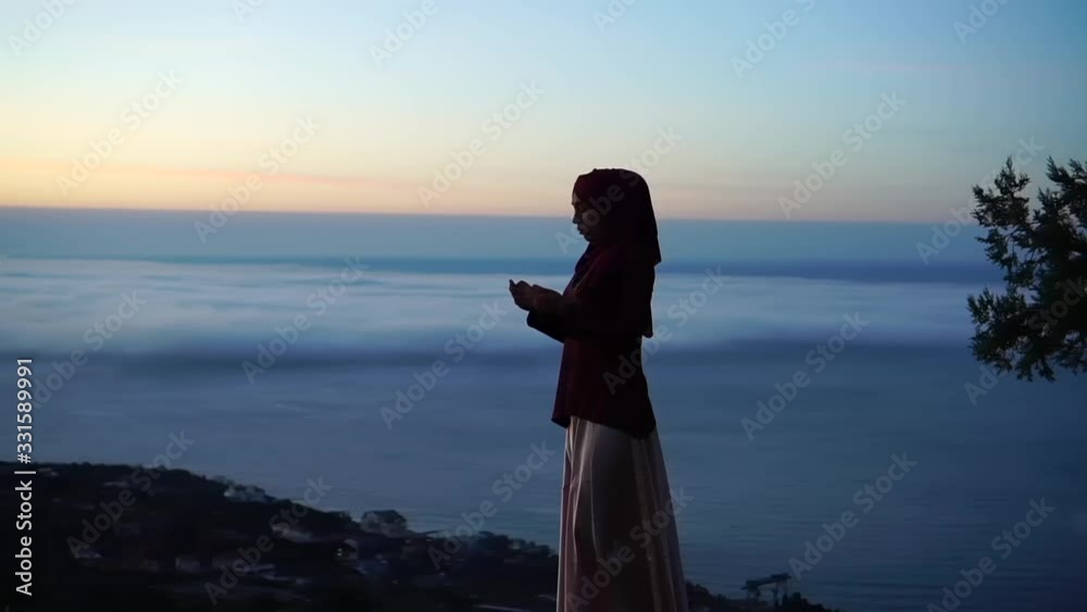 Muslim woman prays. Salat Al-Fajr prayer dawn, before sunrise. Fasting ...