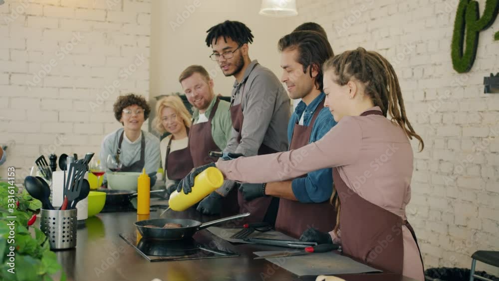 Group of cookery school students is cooking meat with fire enjoying ...