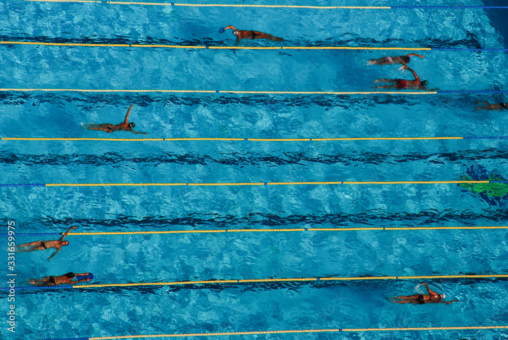Olympic pool seen from above with people swimming and enjoying the cool ...