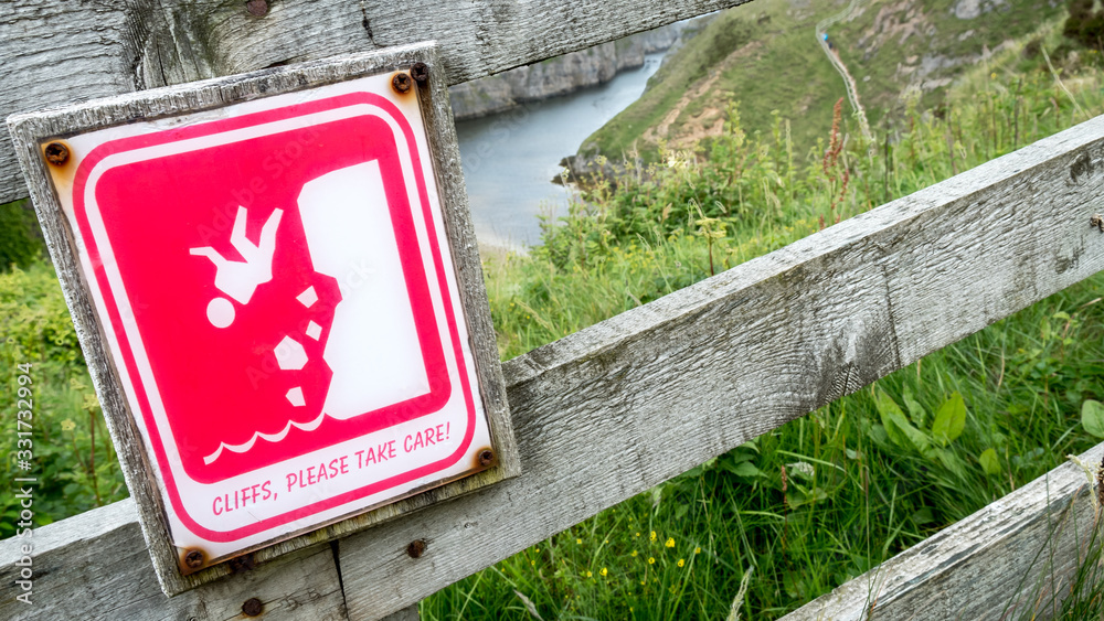 Safety warning sign at Smoo Cave cliffs, Scotland. An illustrated sign ...