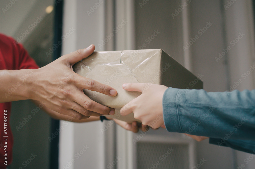hand of delivery service man in red uniform with woman customer ...
