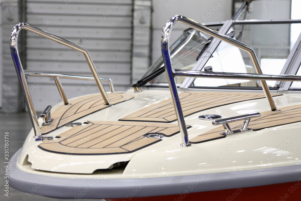 Metal railings on white motor boat bow deck close up with brown marine ...