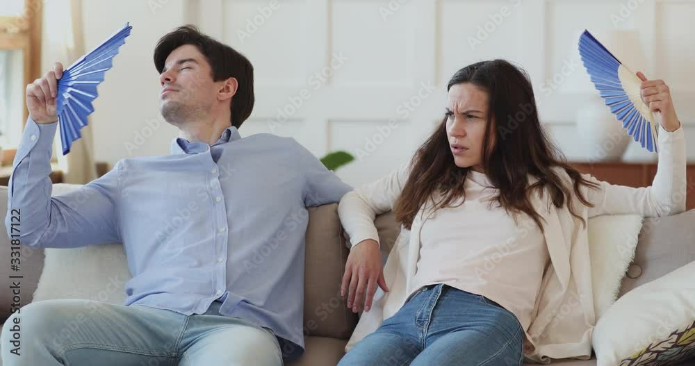 Unhappy frustrated couple suffering from heat, bad air conditioning at ...
