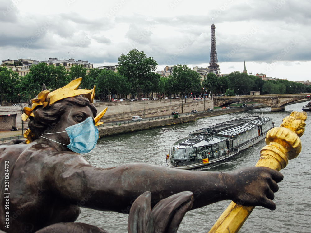Statue at Alexander III bridge wearing a surgical face mask as a symbol ...
