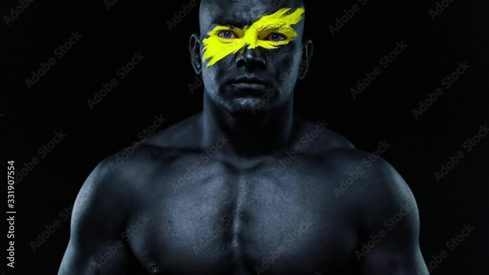 Closeup portrait of man bodybuilder athlete with yellow color on face ...