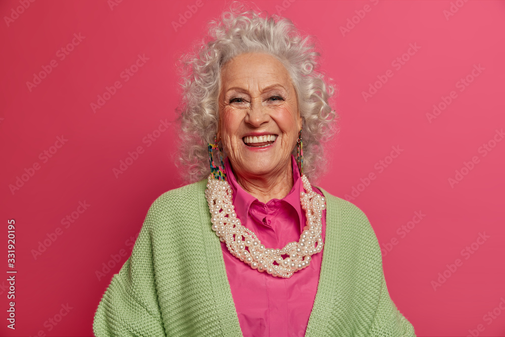 Headshot of good looking elderly woman smiles broadly, makes photo for ...