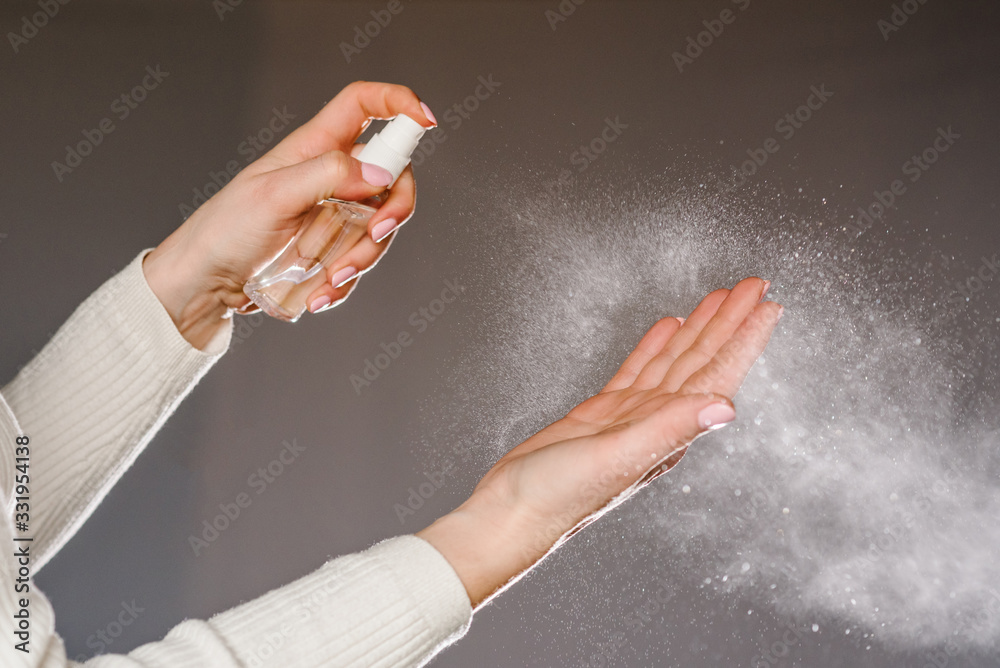 Hands applying alcohol spray or anti bacteria spray. Personal hygiene ...